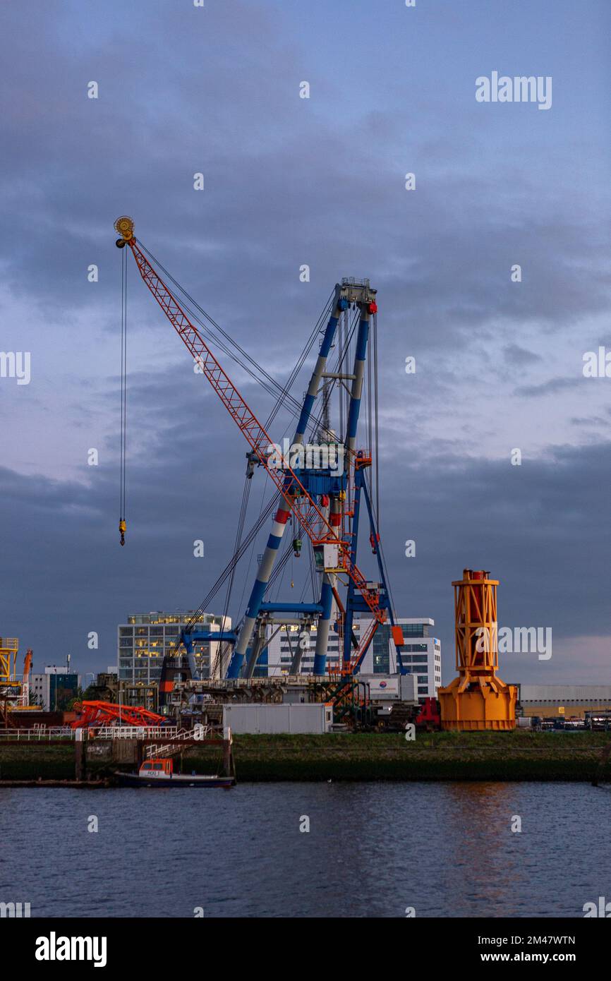Industrial inland shipping colourful cranes in port at sunset blue hour ...