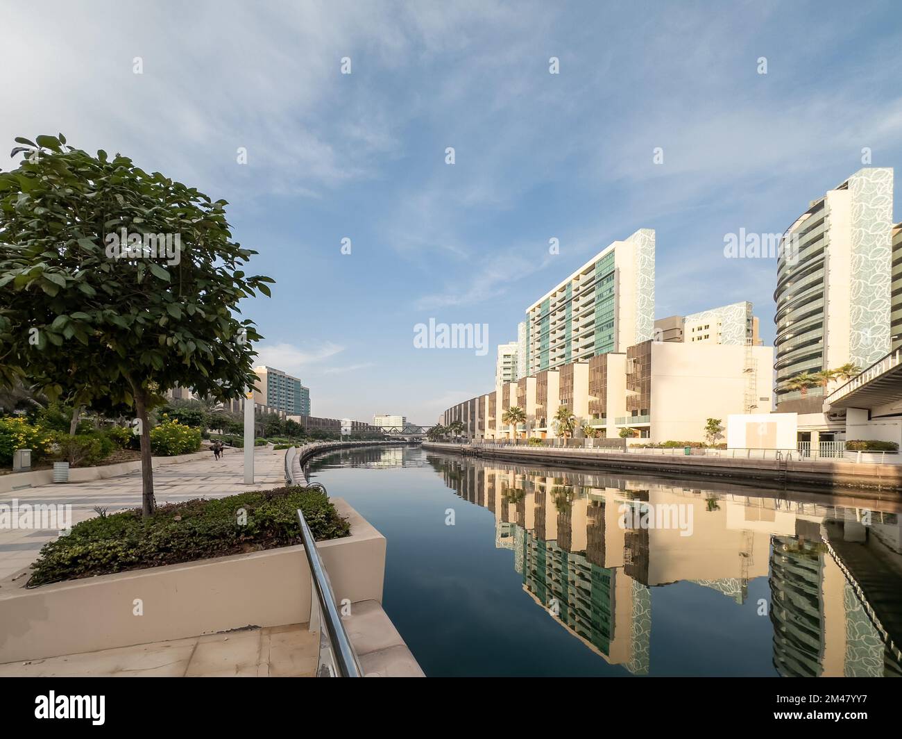 Reflections of apartment buildings along a waterfront promenade in Abu ...