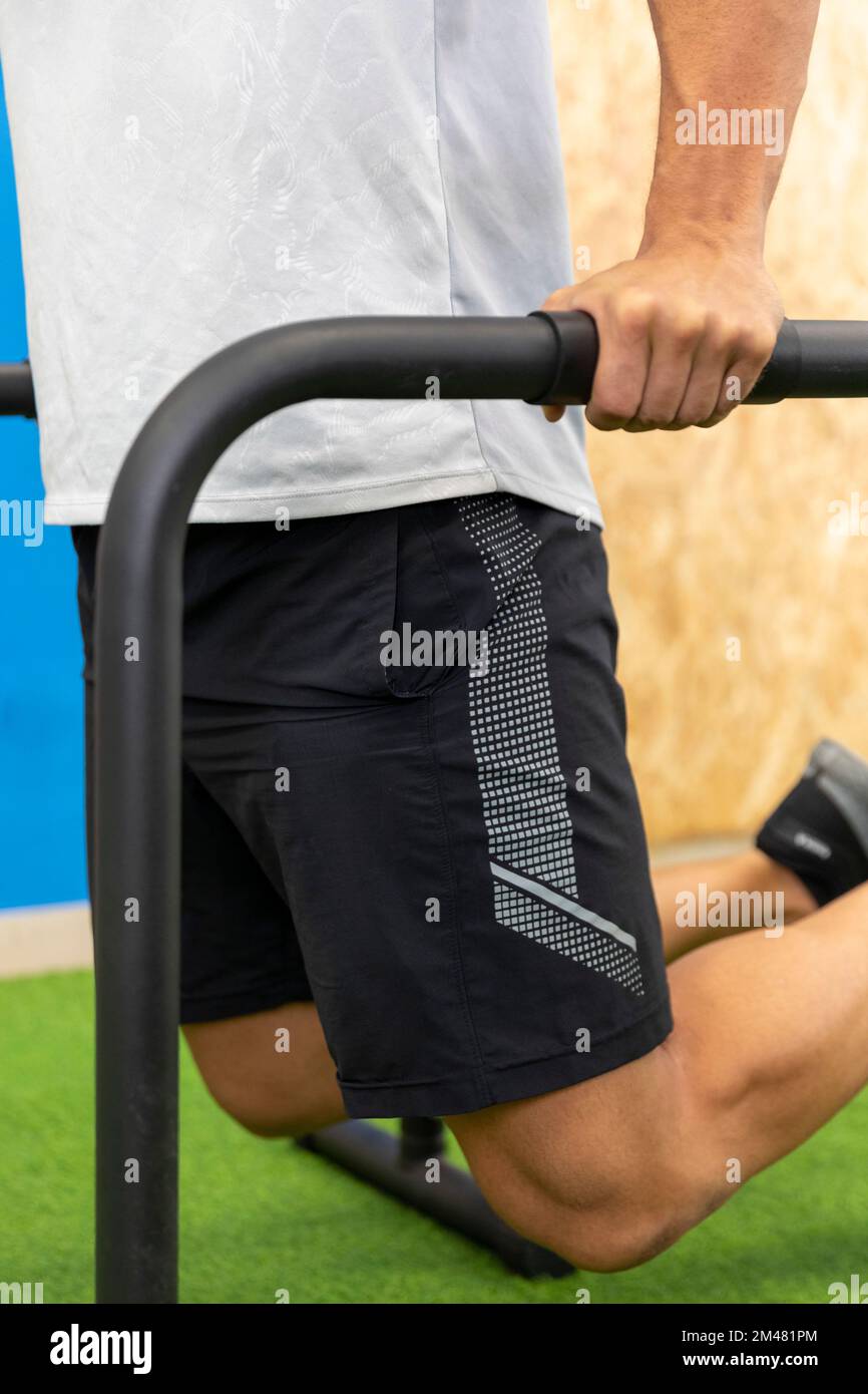 Side photo of an unrecognizable young man exercising with bent legs on ...