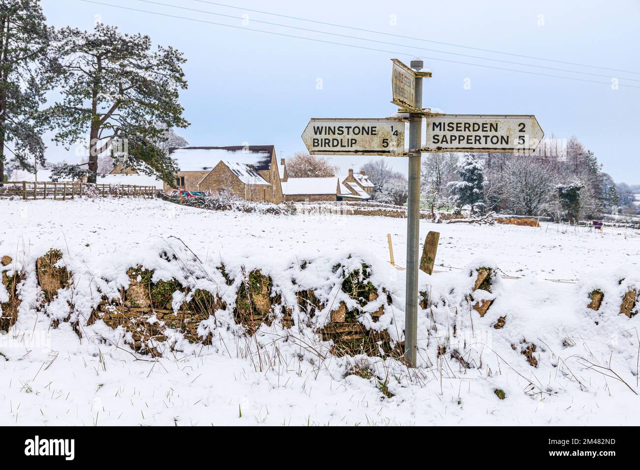 A road sign in early winter snow near the Cotswold village of Winstone ...