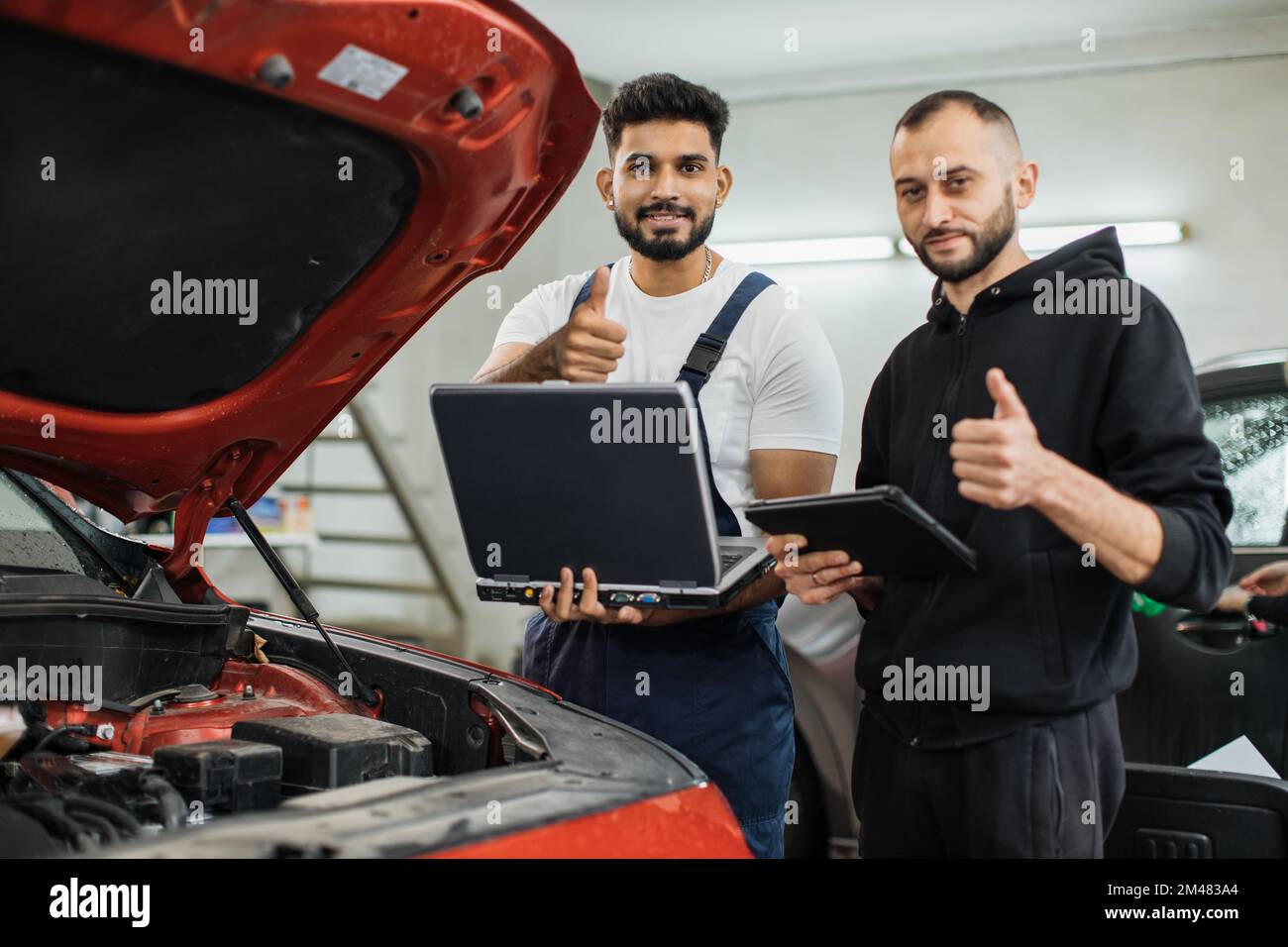 Serious focused men car technician mechanics repairing car problem of ...