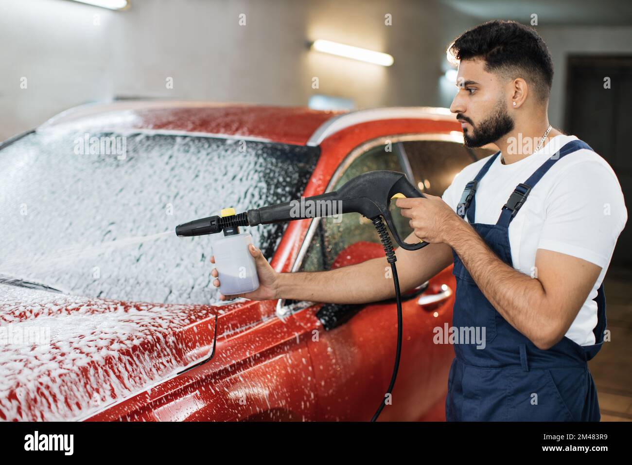 Close up portrait of car wash worker, hansome young man in protective ...