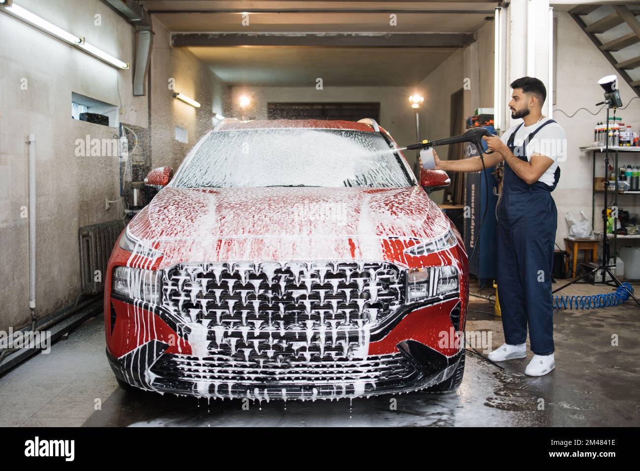 Side view portrait of young pleasant car wash worker, wearing ...