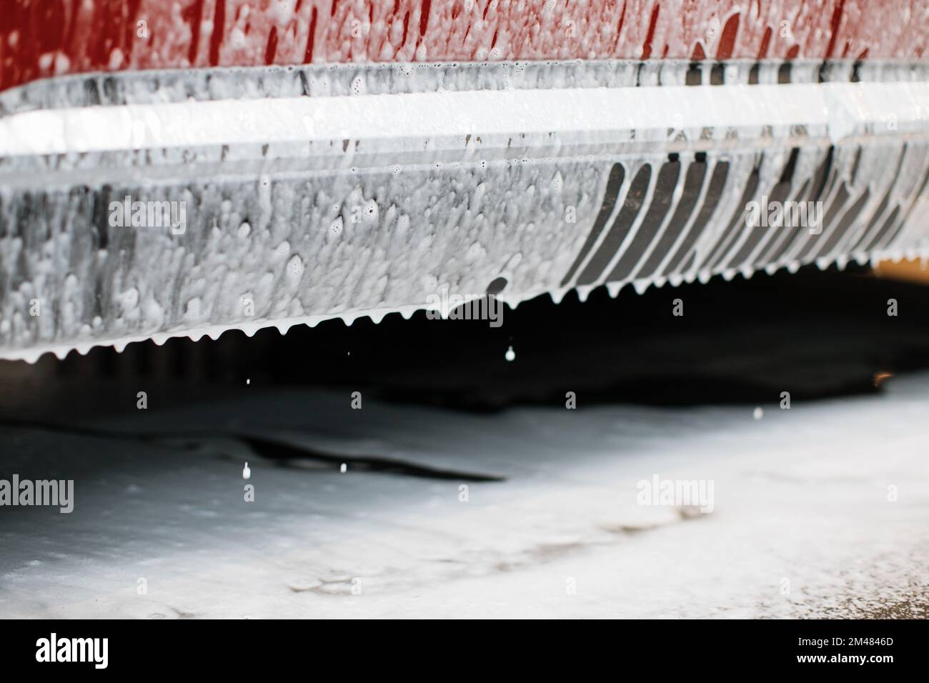 Washing a car threshold at auto wash service. Soapy red car. Washing of ...