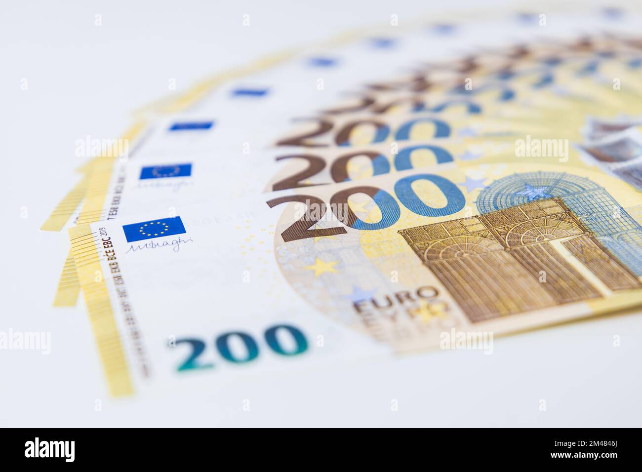 A closeup of the 200 Euro banknotes with patterns on a white background ...