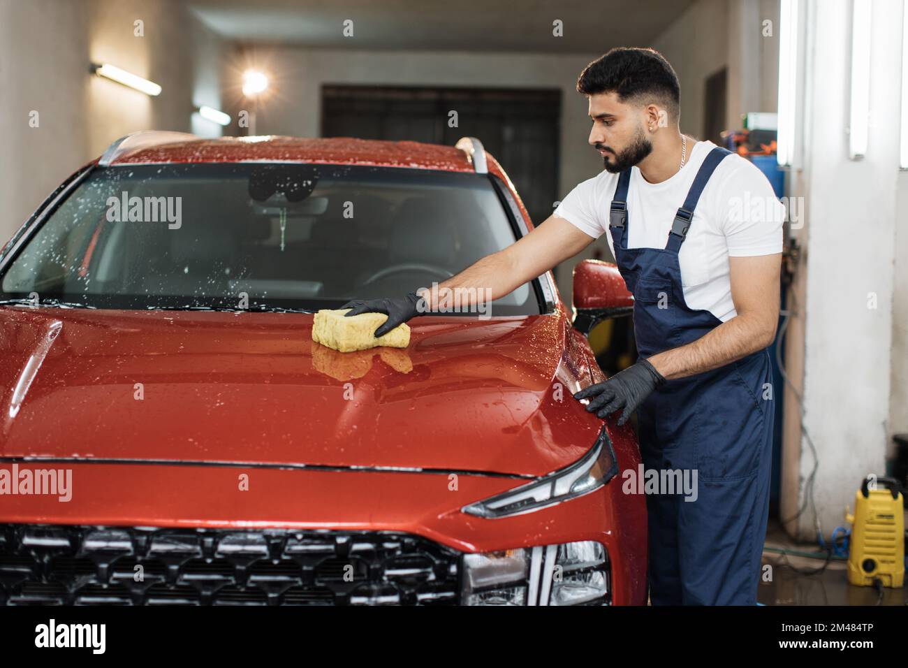 Car washing and detailing concept. Young concentrated bearded male ...