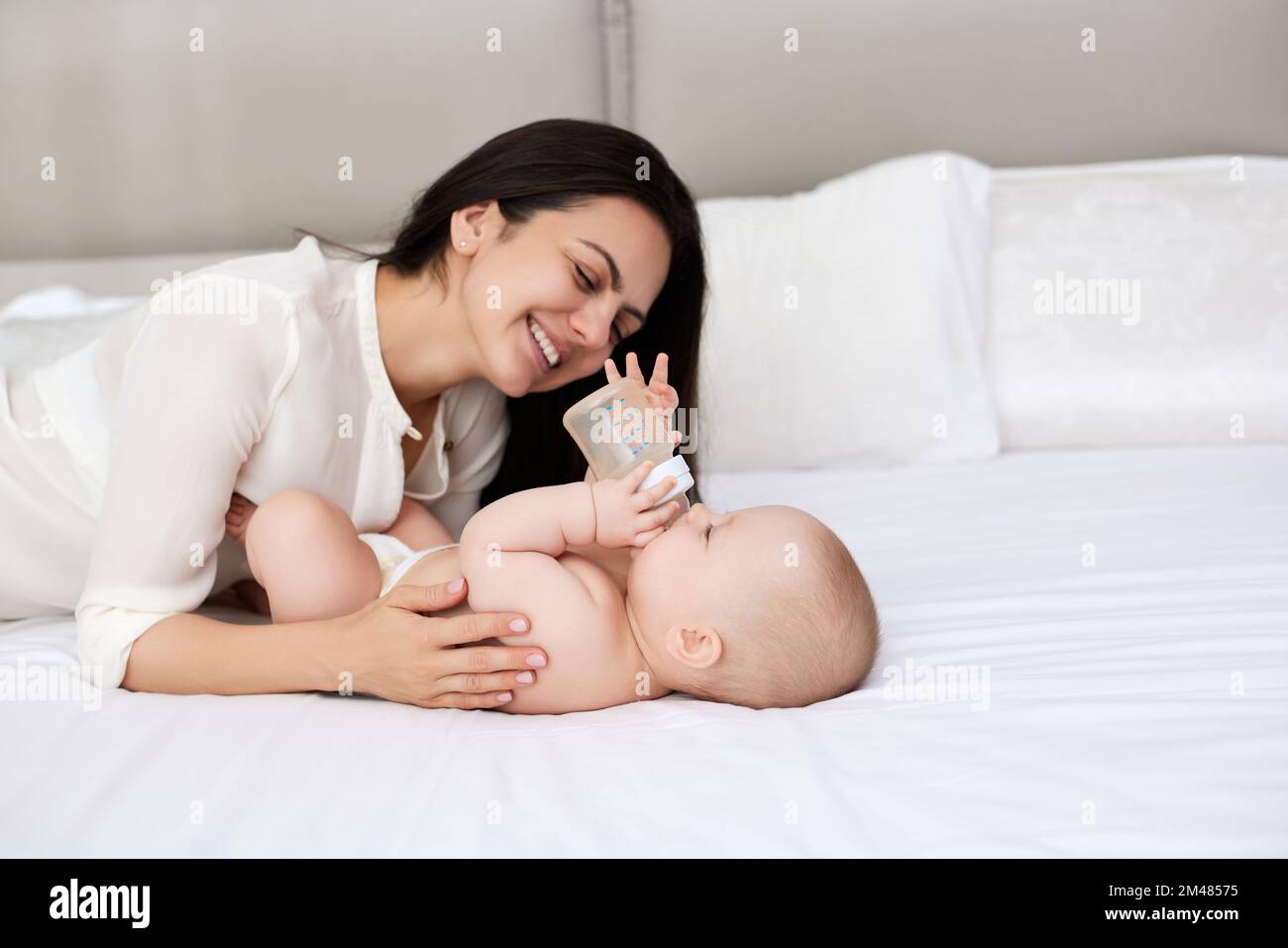 happy mother feeding her newborn baby on the bed Stock Photo - Alamy