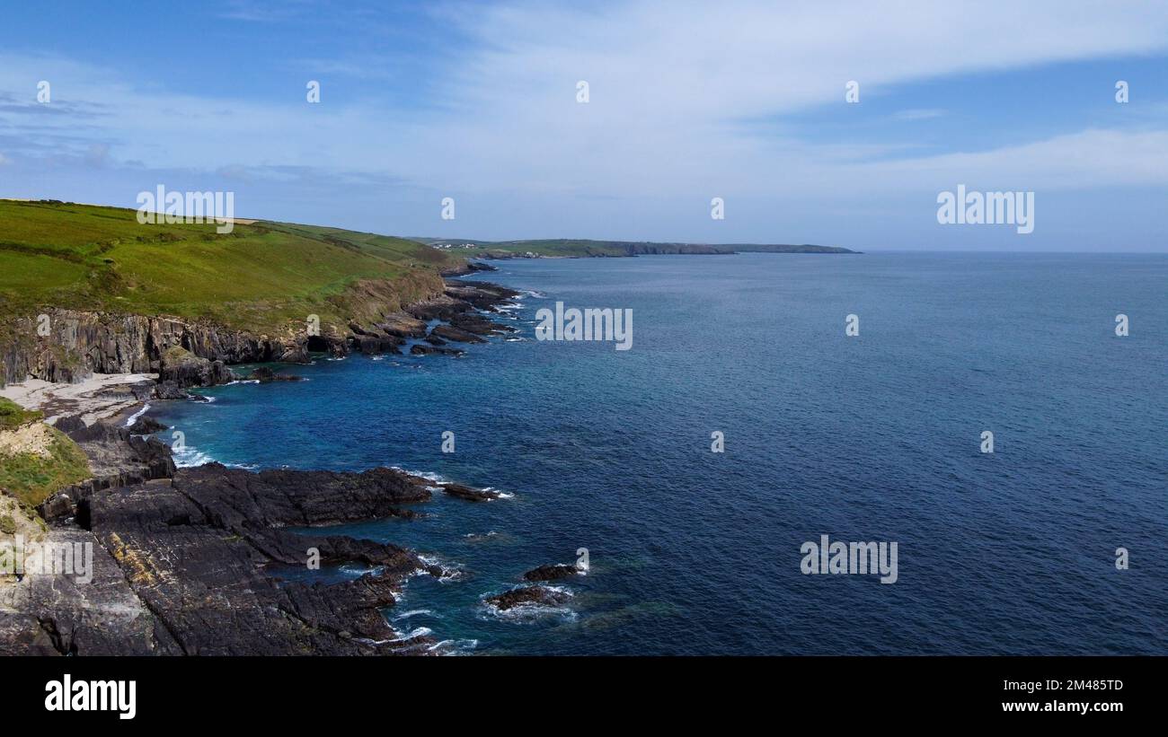 Green hills on the Atlantic Ocean on a sunny spring day. Blue sky over ...