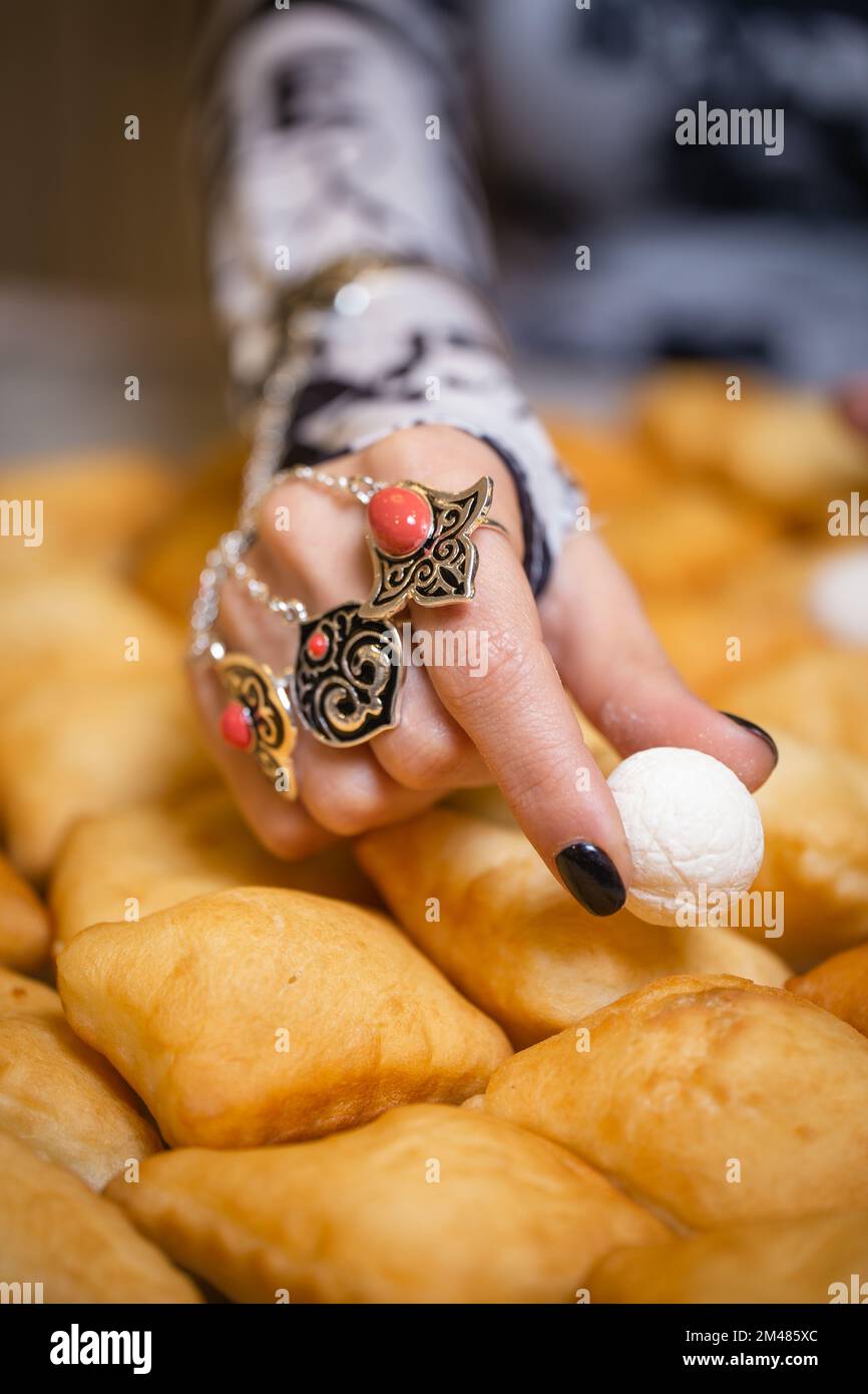 Kazakh kurt in a woman's hand against the background of baursaks Stock ...