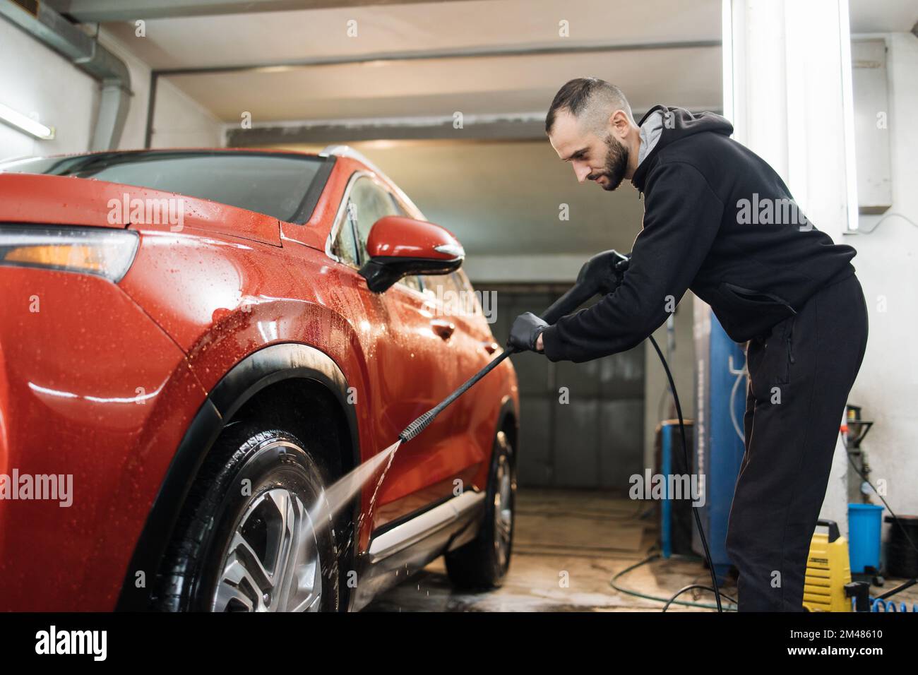 Washing car with high pressure water at car wash service. Close up of ...