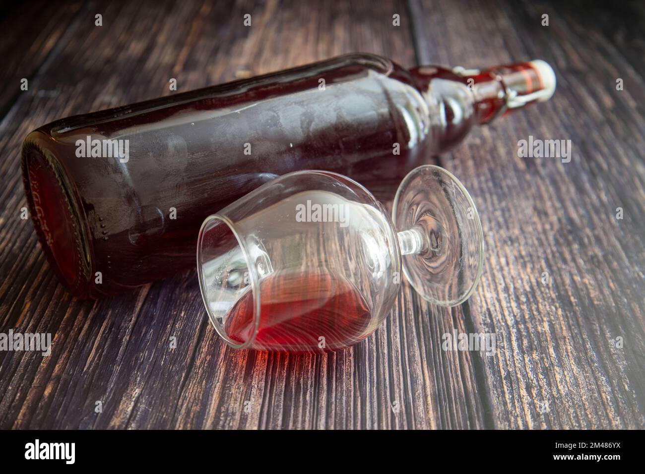 Lying glasses and a bottle of red wine on the table Stock Photo - Alamy