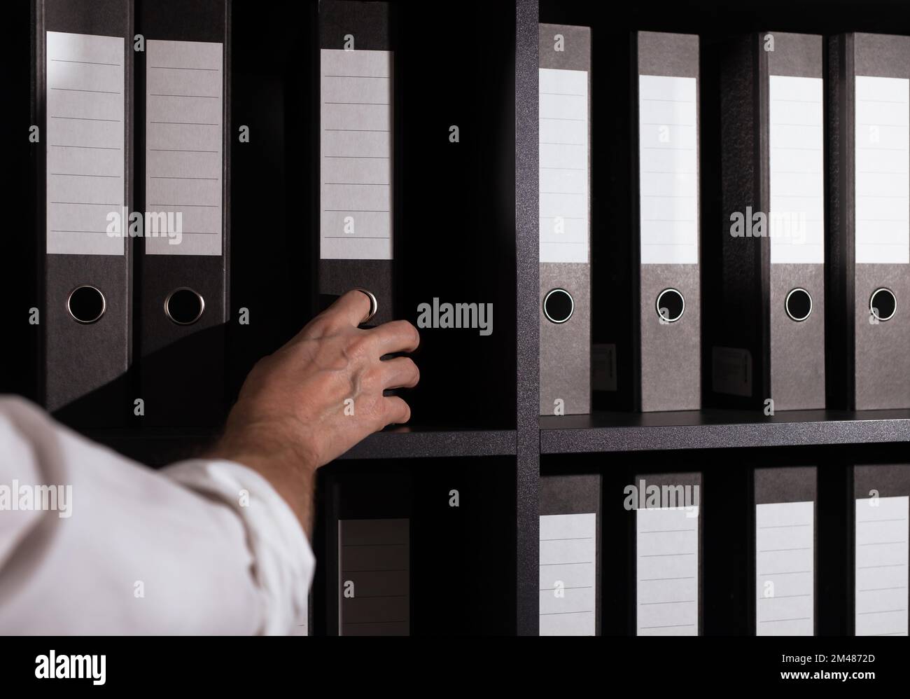 Hand taking folder binder from office shelf. Business documents, files ...