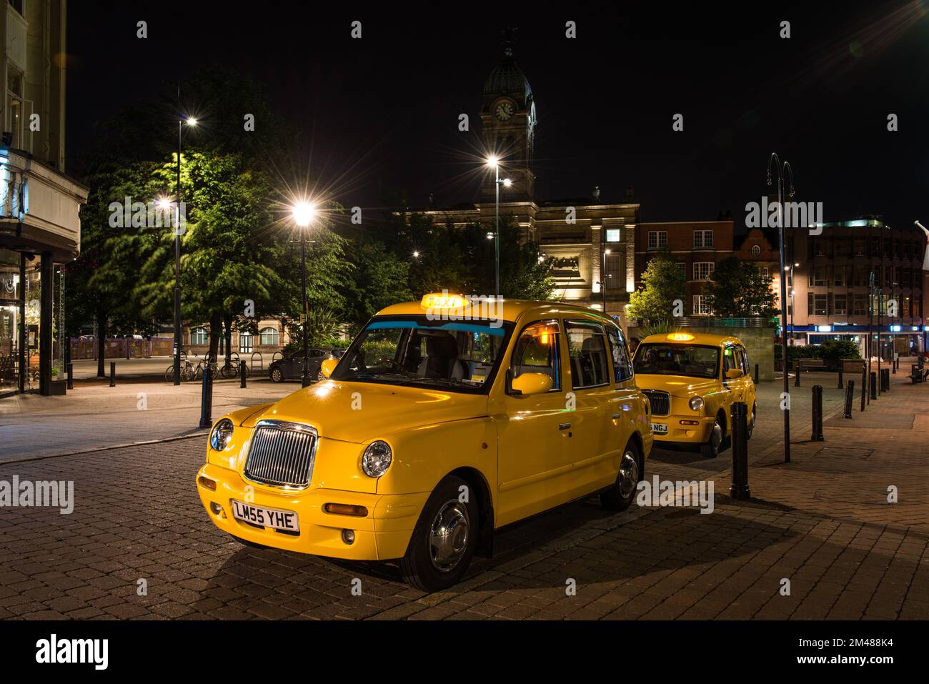 Derby taxi rank at night. With yellow taxis. UK Stock Photo - Alamy