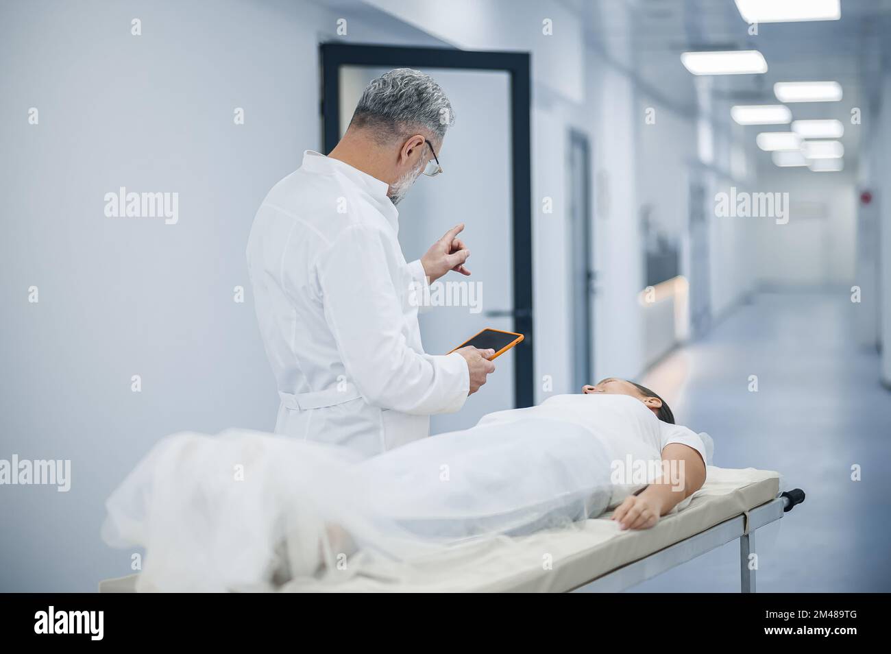 A doctor talking with a patient before MRI procedure Stock Photo - Alamy
