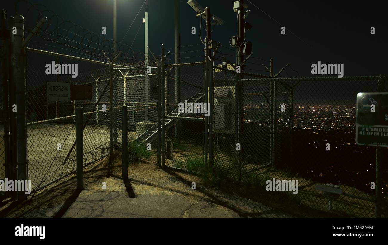 A Facility with metal grid fence next to Hollywood sign at night Stock ...
