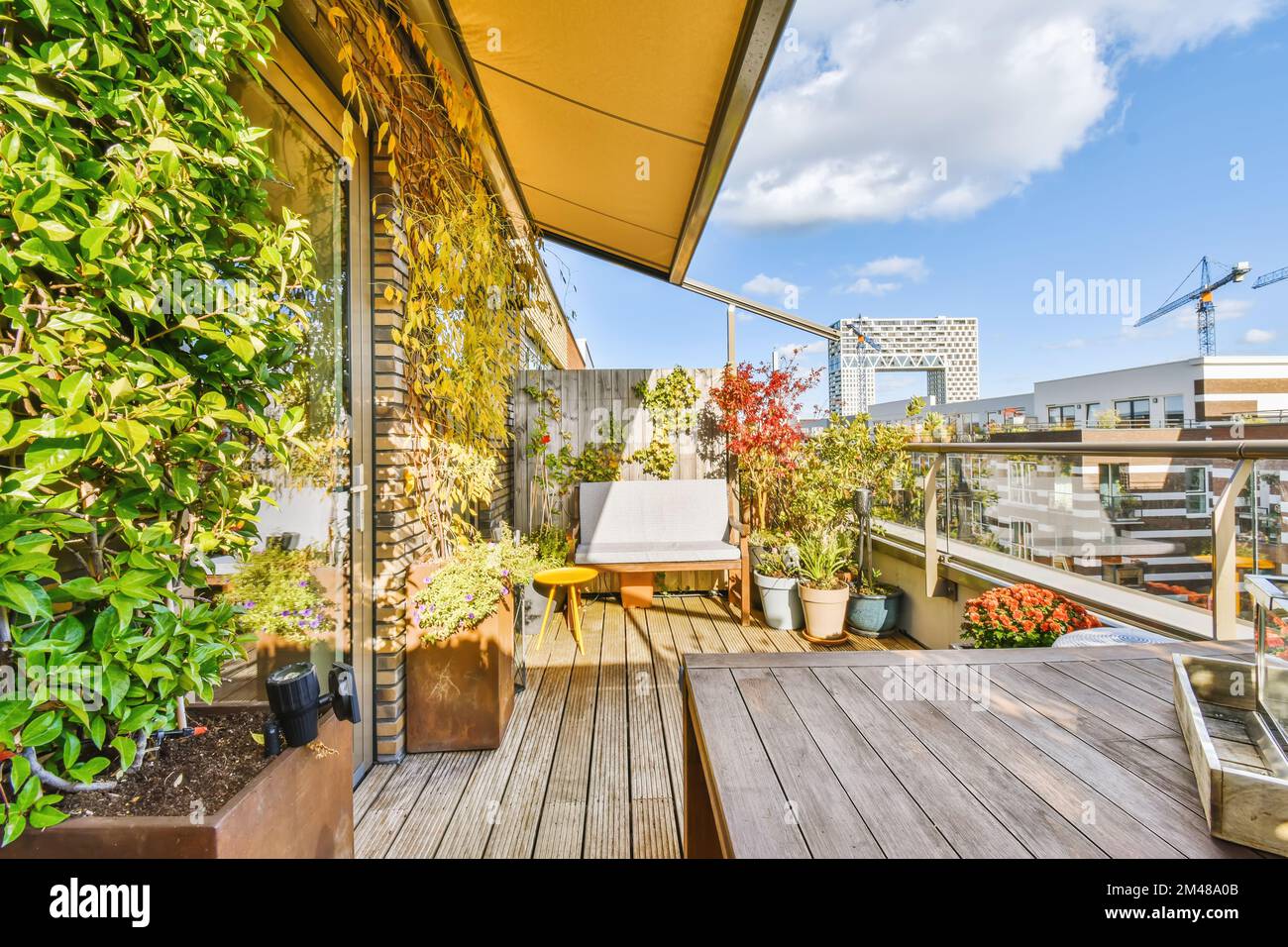 a balcony with plants and pots on the wooden deck, in front of an ...