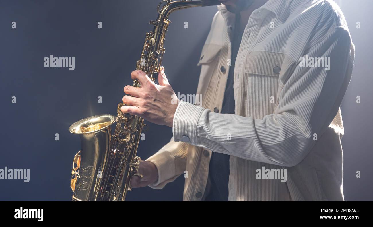 Male musician on stage plays the saxophone dark with smoke Stock Photo ...