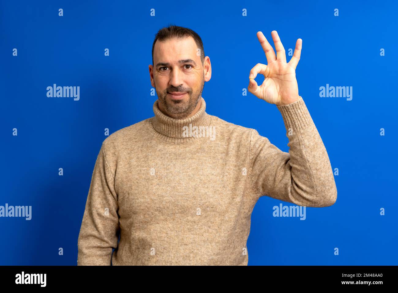 Hispanic man wearing brown turtleneck unshaven happy smiling and ...