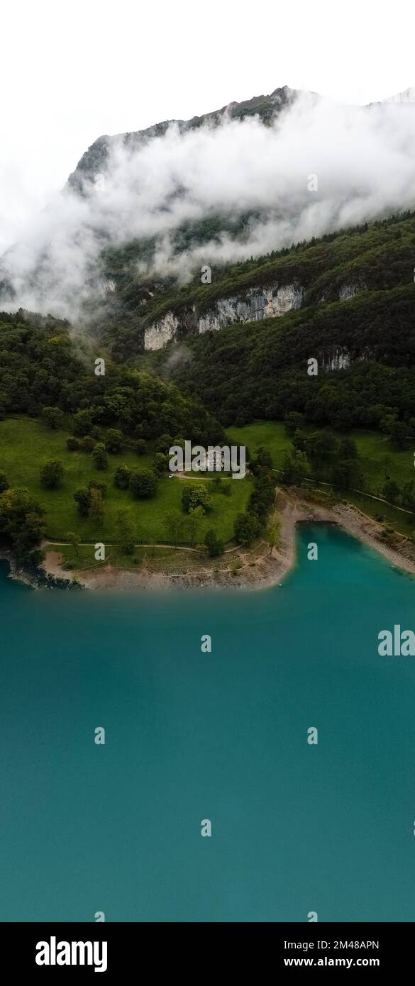 A vertical bird's eye view of an azure pond surrounded by forested ...