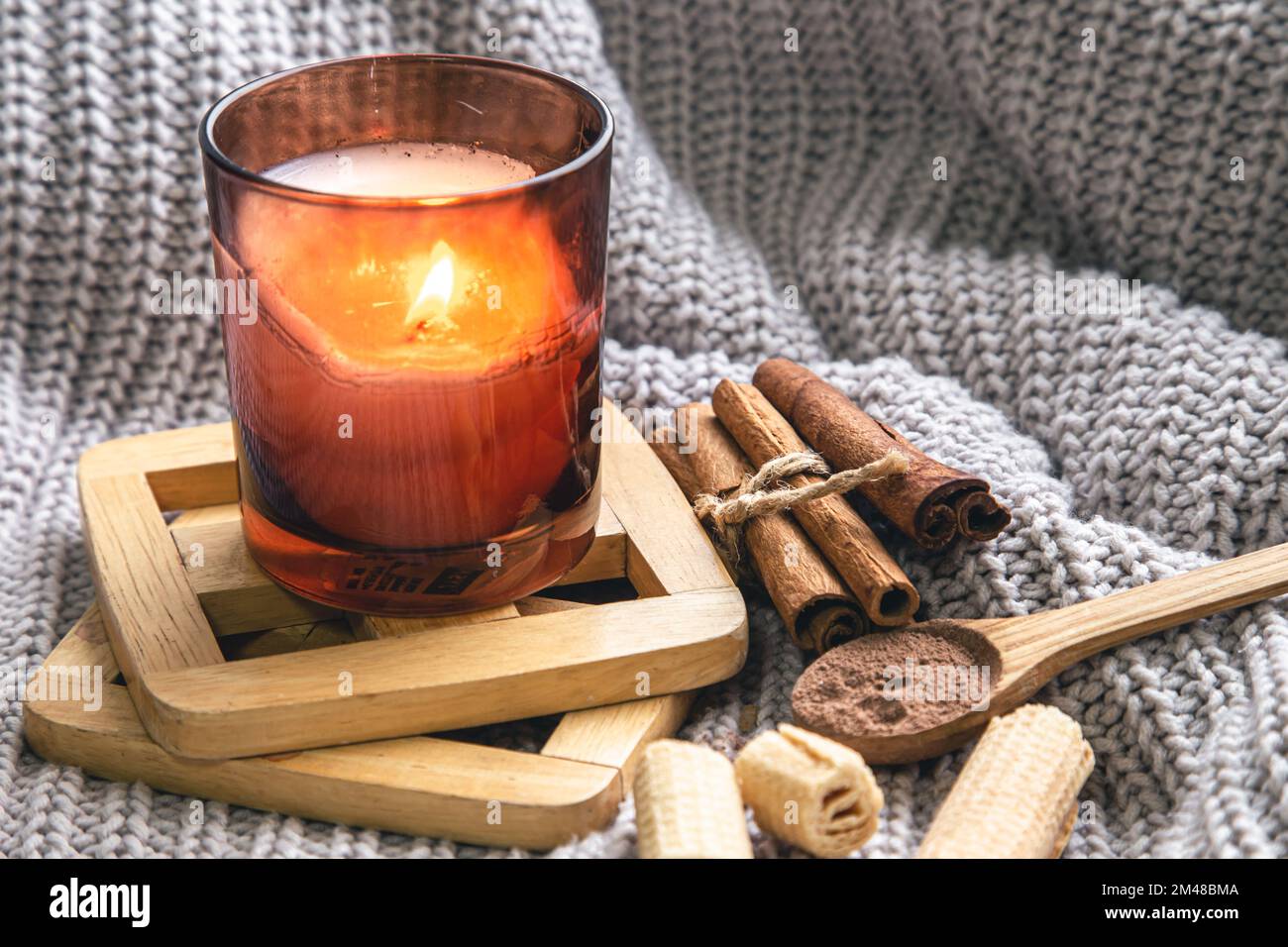 Burning candle and cookies on a blurred background with a knitted ...