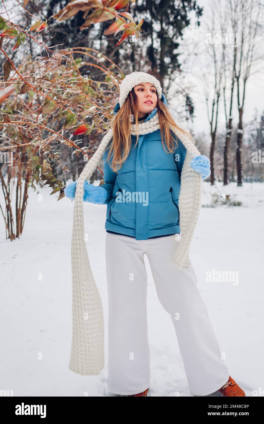 Full body portrait of young woman walking in snowy winter park wearing ...