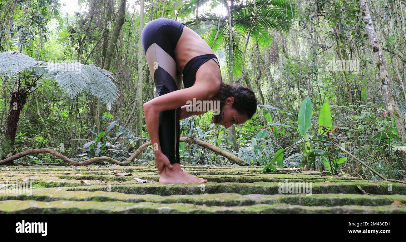 Yogi woman stretching legs outdoors in tropical jungle Stock Photo - Alamy