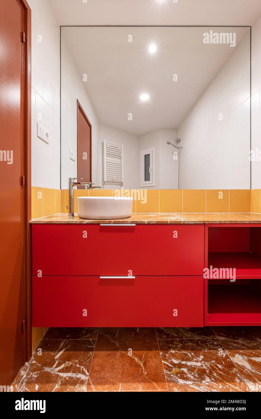 Overhead white sink on a red cabinet in a bright white and yellow ...