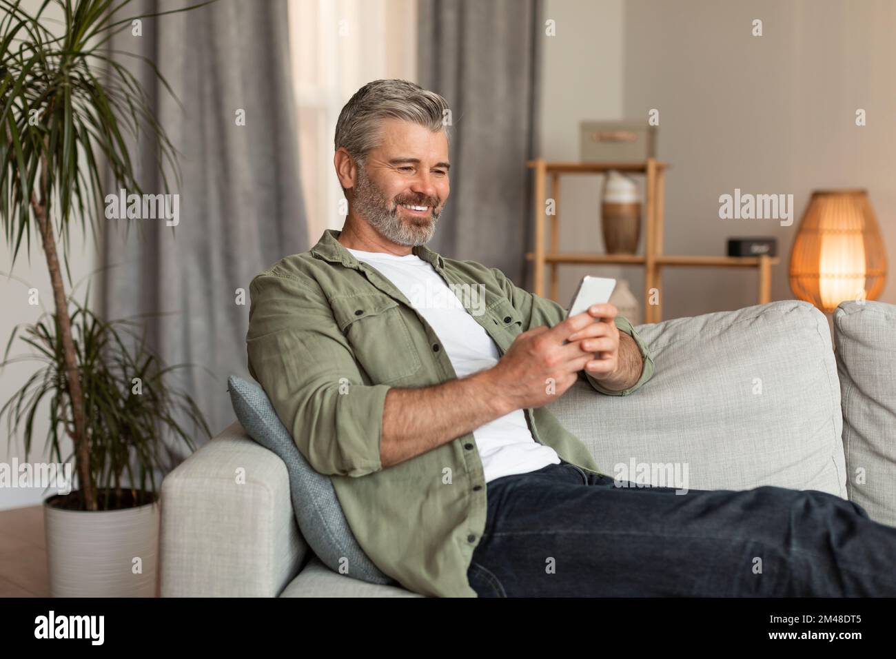 New normal for retired people. Smiling old caucasian male typing on ...