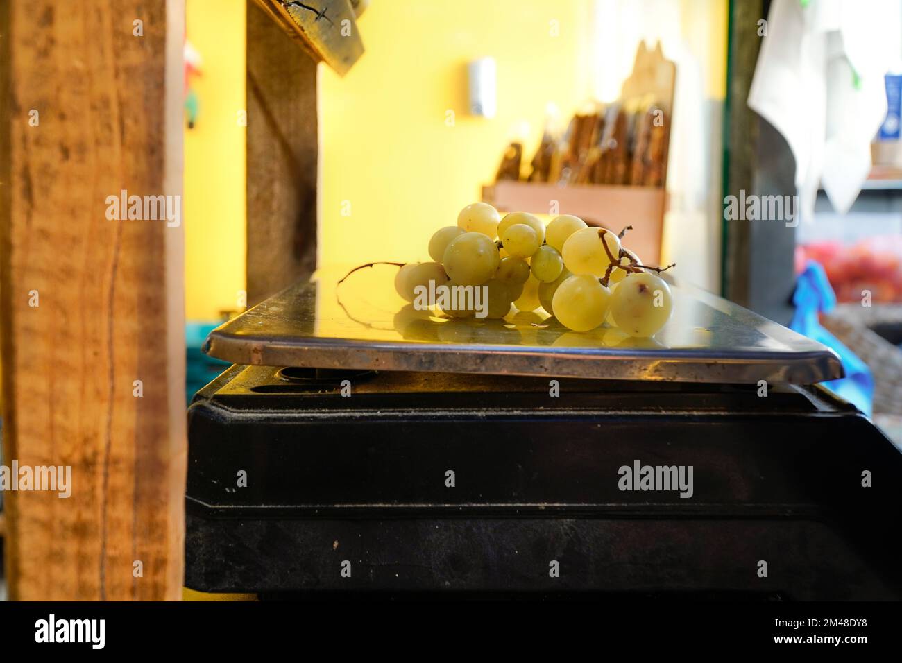 a vegetable store. Some grapes on the scale Stock Photo - Alamy