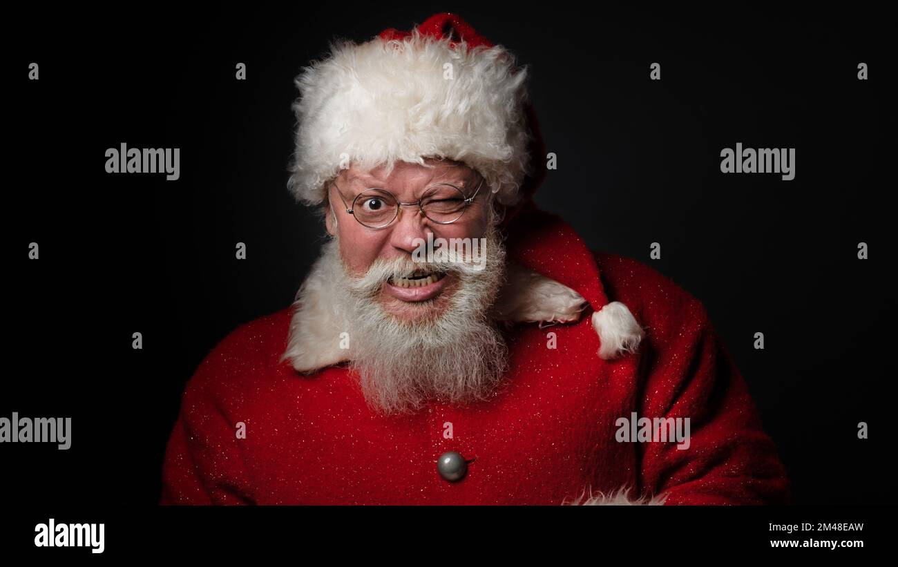 Santa Claus looking into the camera at black background Stock Photo - Alamy