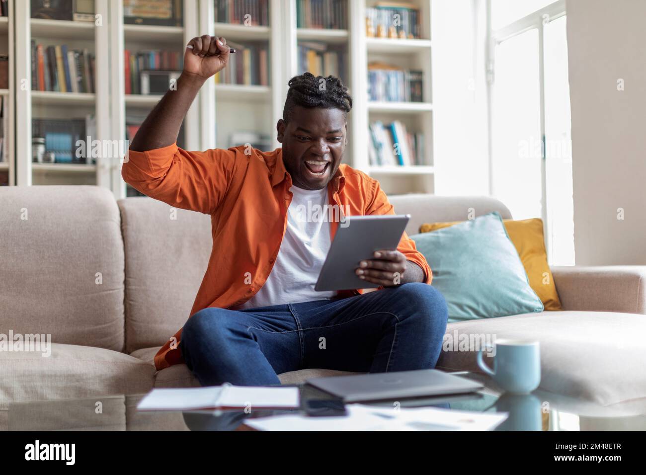 African american plump guy student passing test online Stock Photo - Alamy