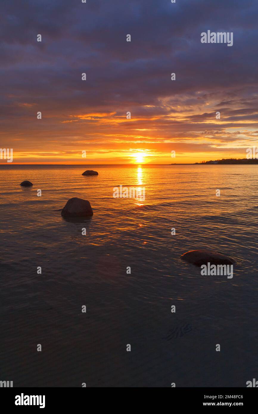 Red sky over a rocky seashore. Sunset landscape Stock Photo - Alamy