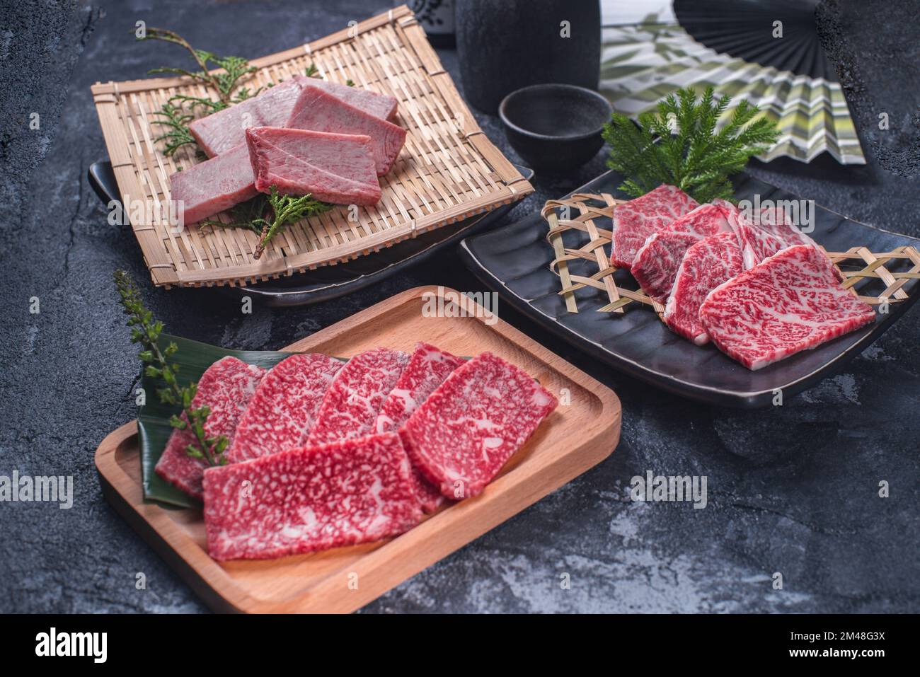 A close-up shot of raw marble meat slices on trays and plates Stock ...