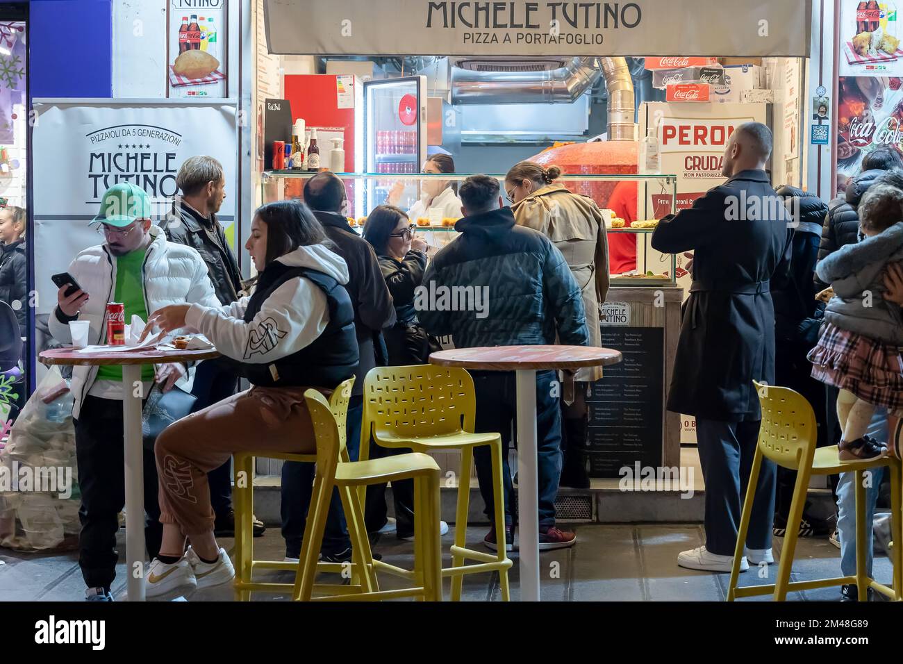 Naples, Italy - December 11, 2022: Group of people buy and eat food in ...
