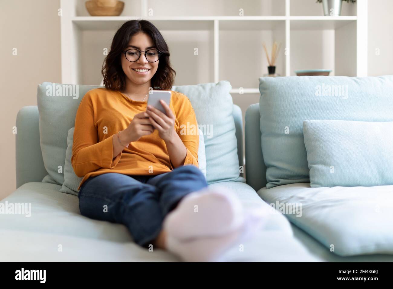 Beautiful Arab Female Wearing Eyeglasses Relaxing On Couch With ...