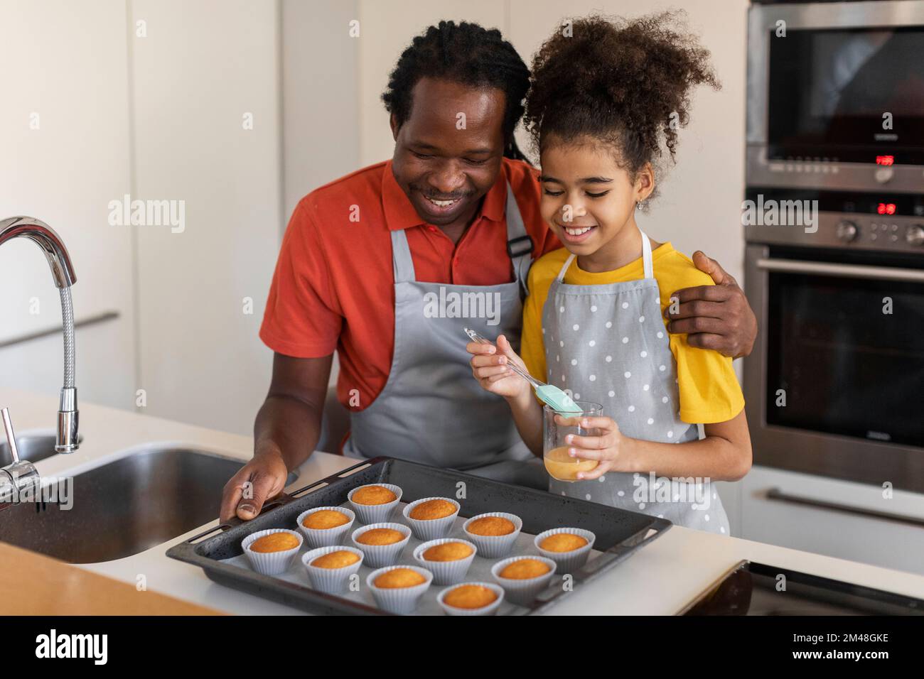 Black Dad And Female Child Baking Muffins Together At Home Stock Photo ...