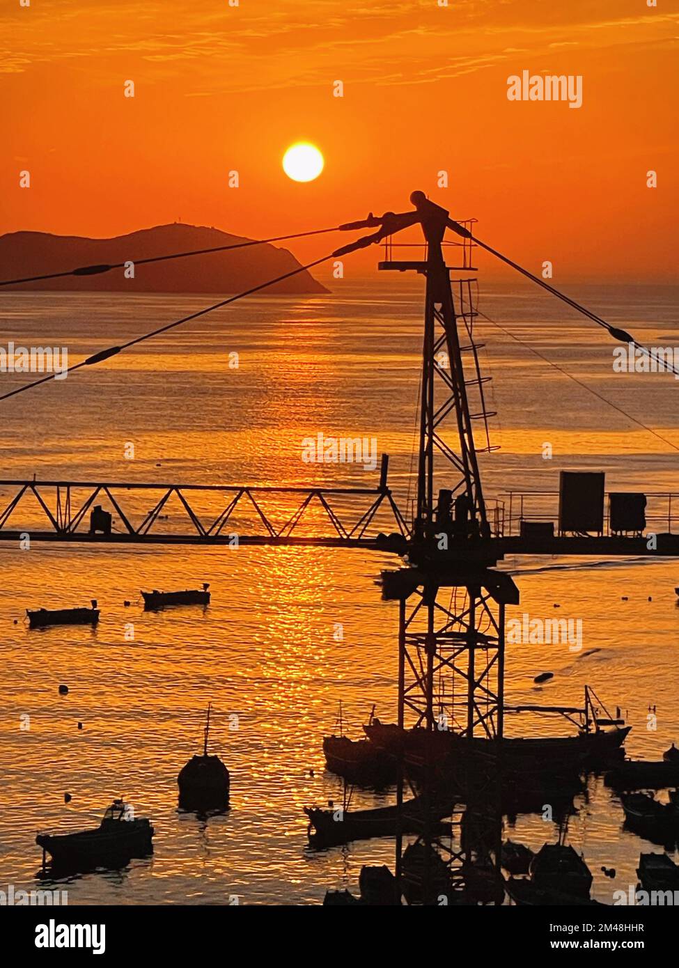 A silhouette of an electric pillar by the sea on the sunset Stock Photo ...