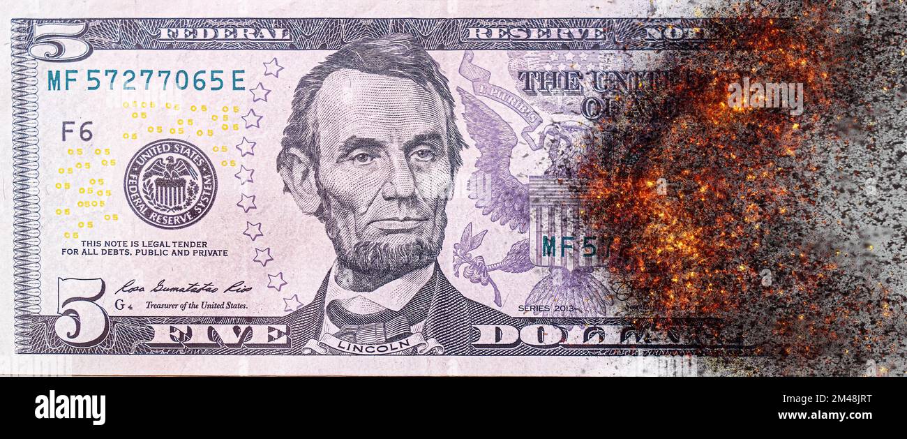 Burning money 5 dollar on fire Stock Photo - Alamy