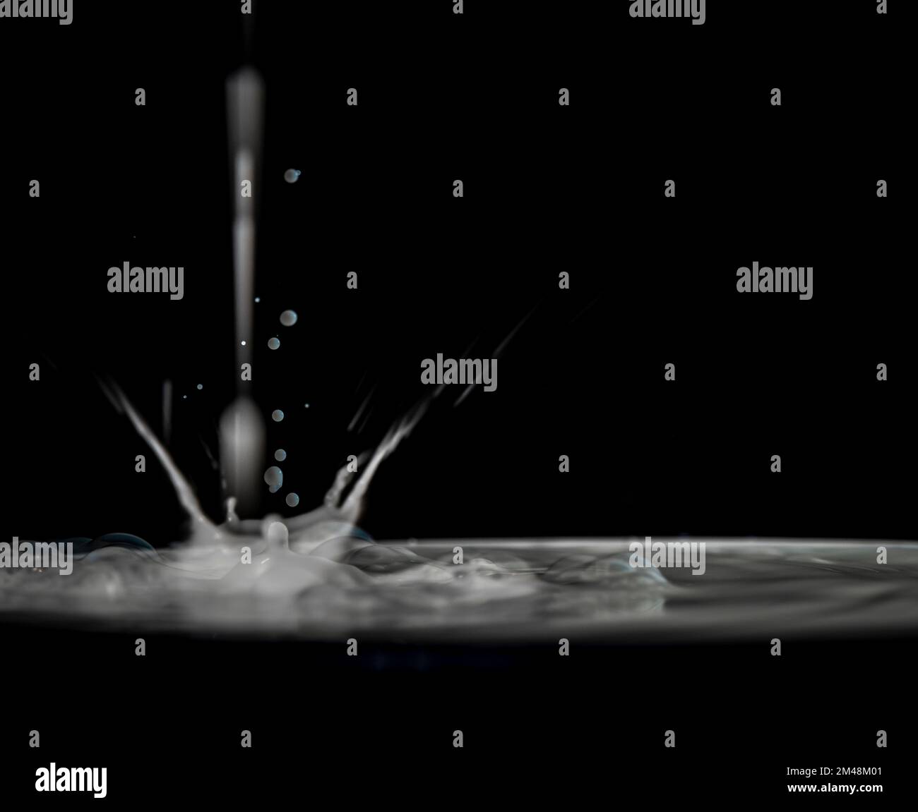 Drop of milk with big waves on surface with dark black background Stock ...