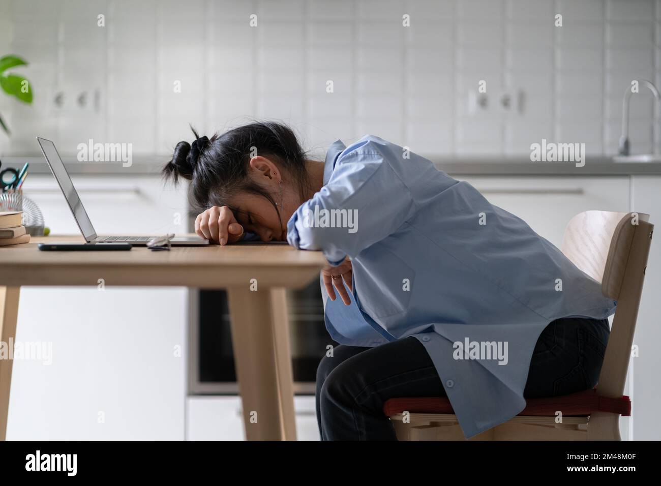 Tired exhausted Asian girl freelancer sleeping while working from home ...