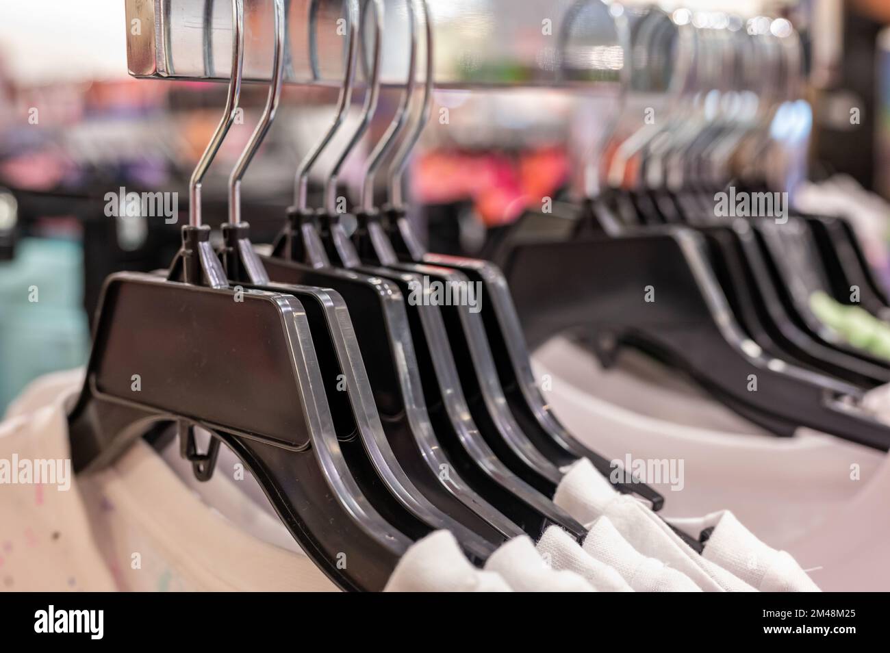 Row of coat hangers on a retail store shelf Stock Photo - Alamy