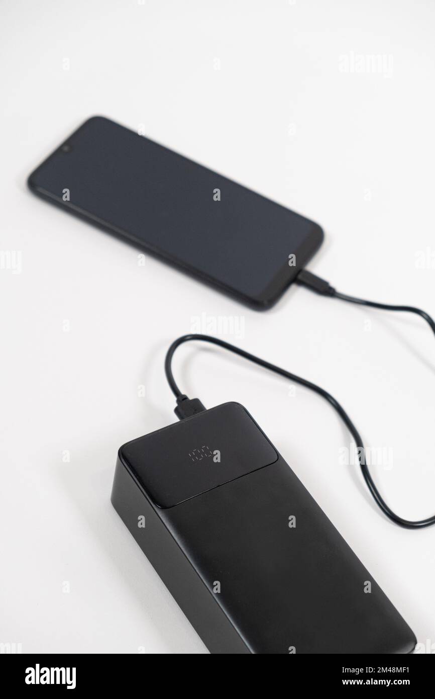 Connecting a mobile phone to a power bank. Charging gadgets from power ...