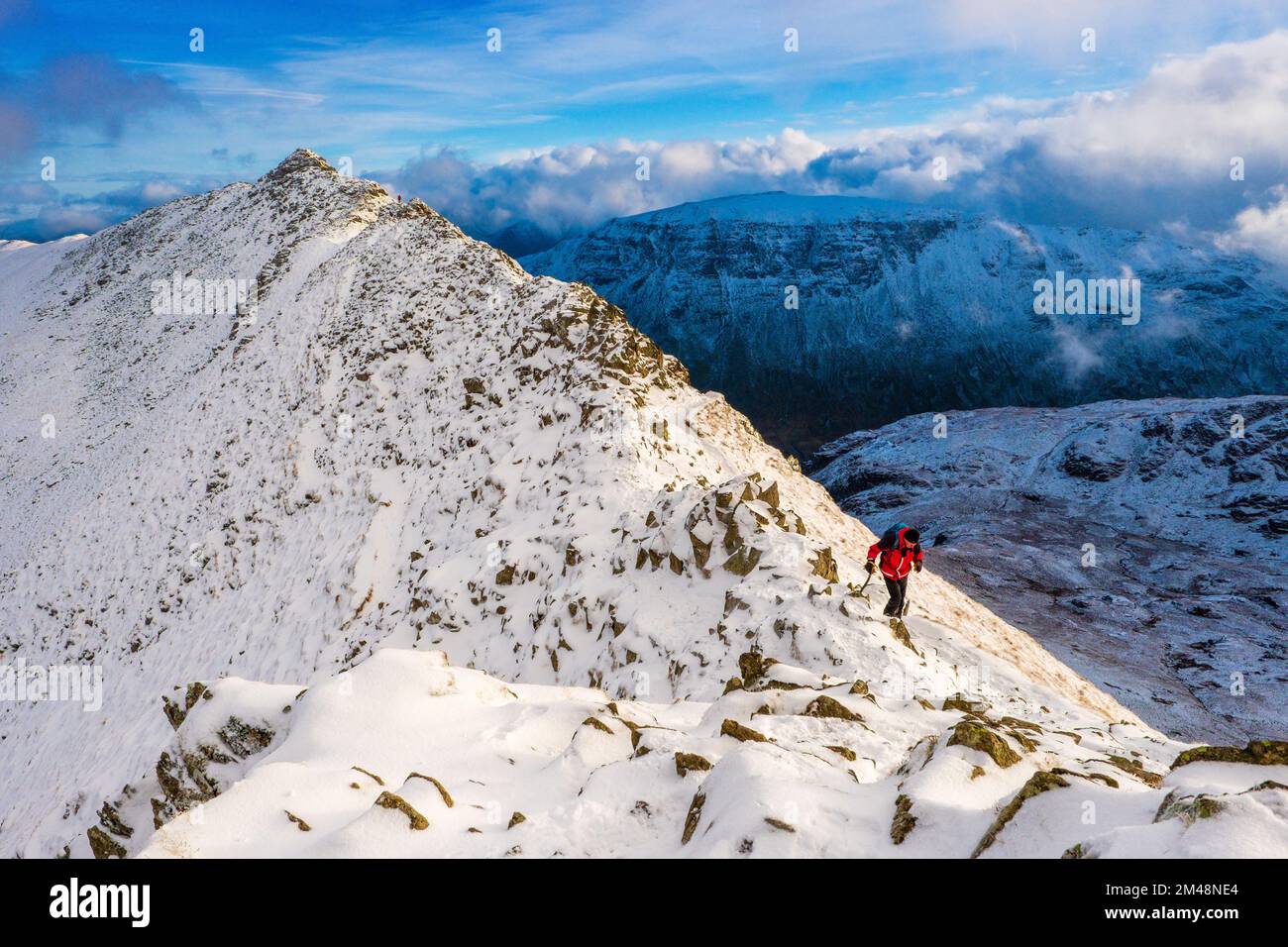 Mountaineers on a winter traverse of Striding Edge on Helvellyn in the ...