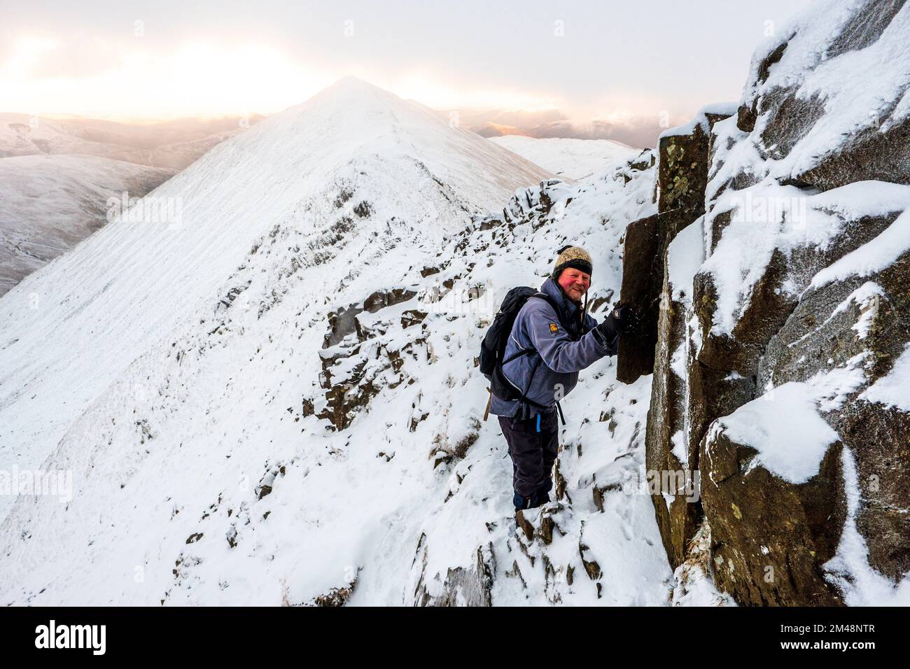 Mountaineers on a winter traverse of Striding Edge on Helvellyn in the ...