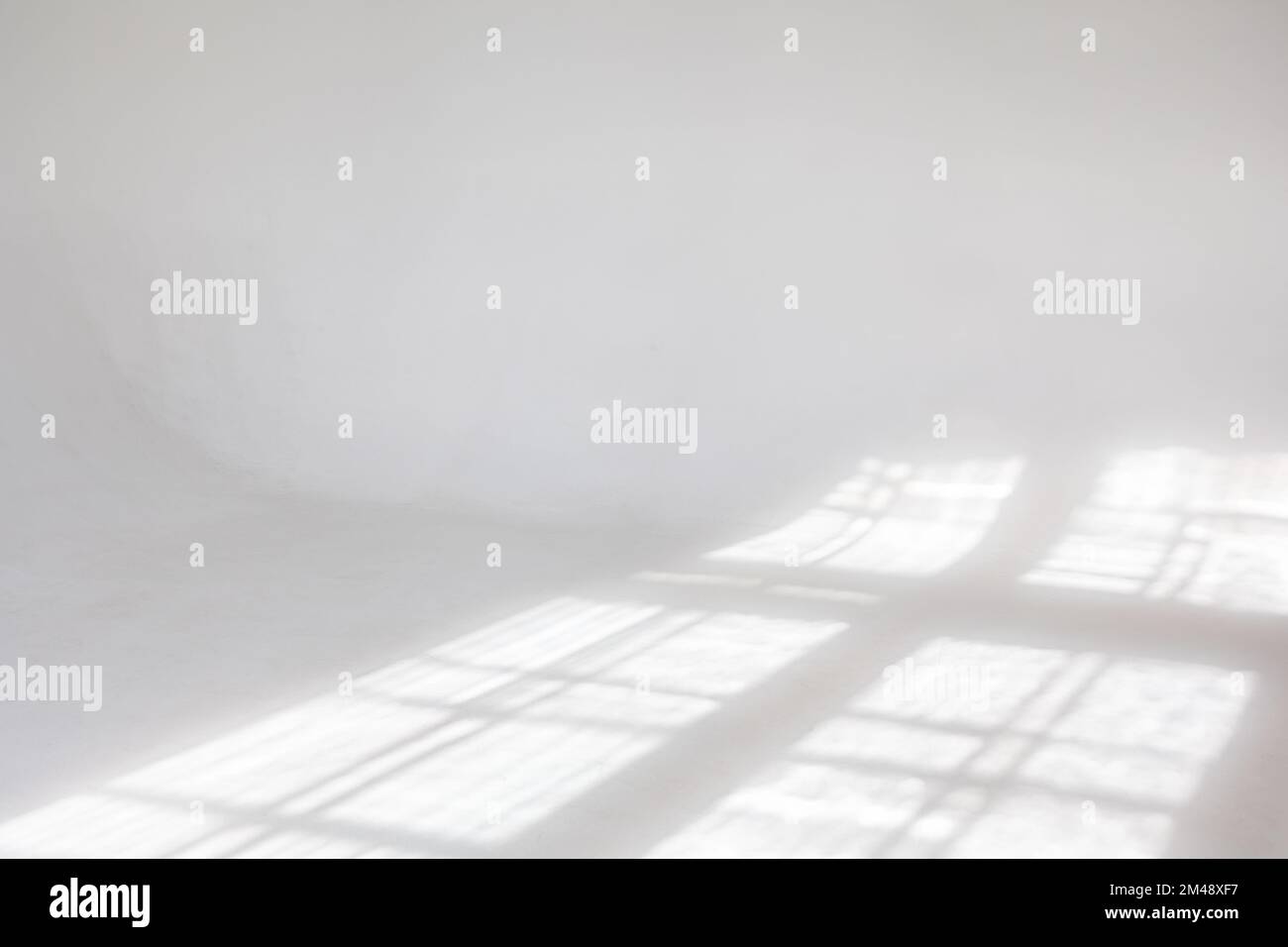 Clear white cyclorama. Light background with sun light and shadows ...