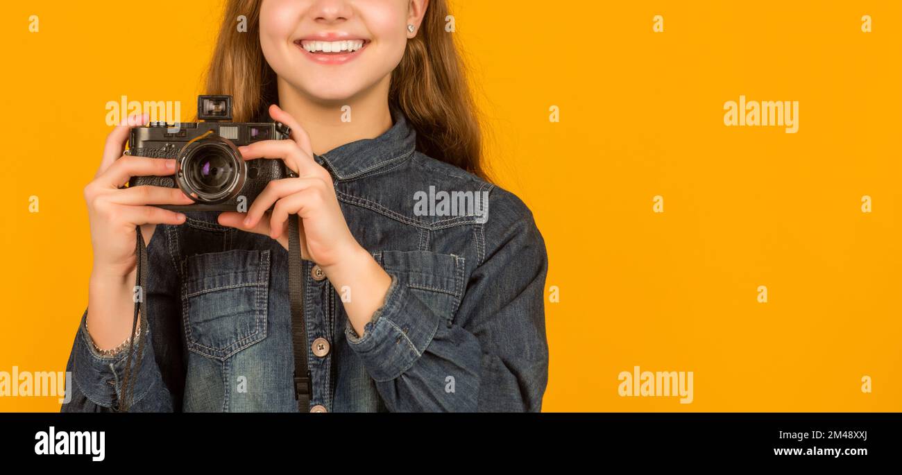 Happy teenage photographer crop view holding camera in hands yellow ...