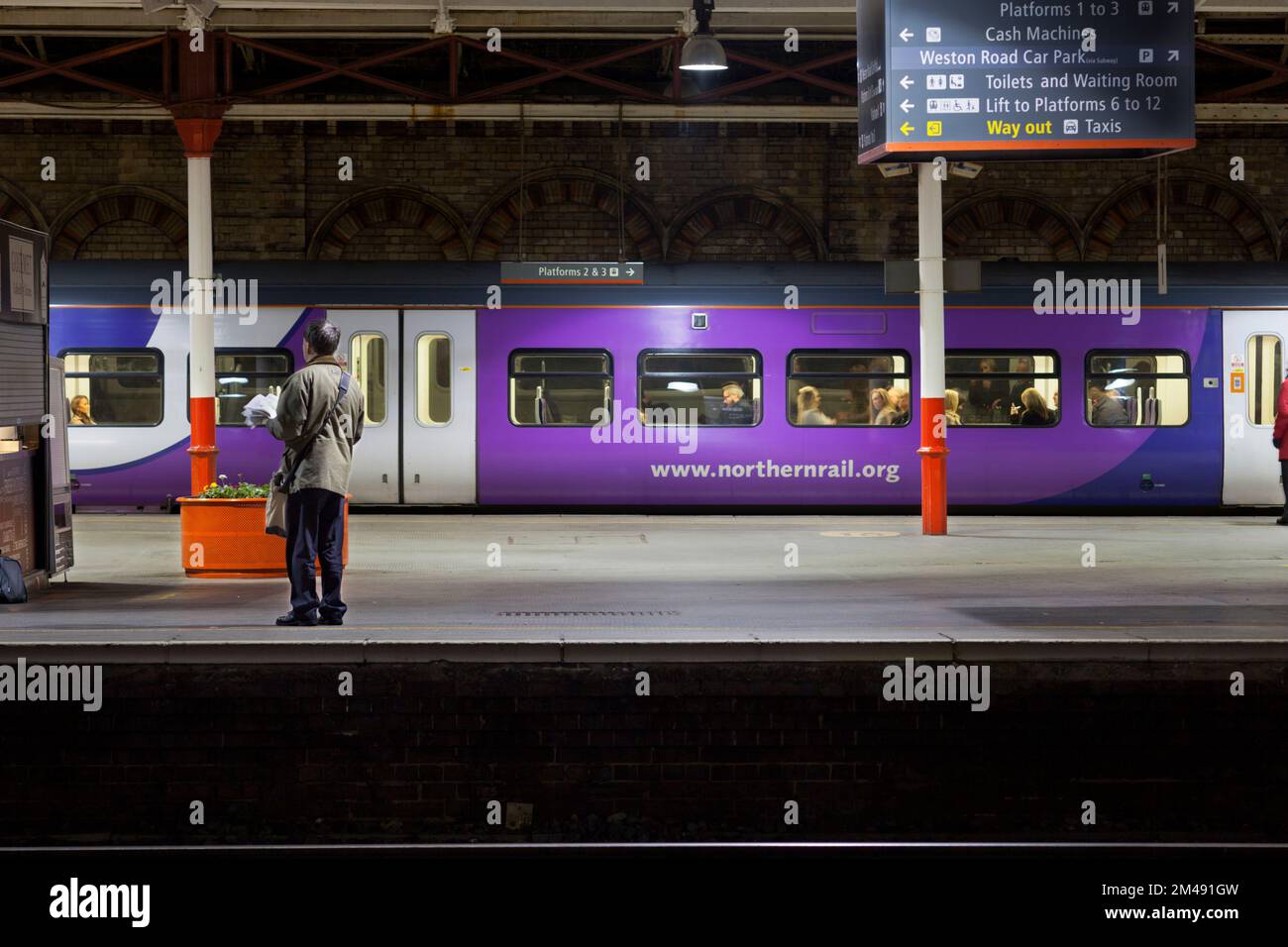 Rail passenger with a Northern rail train at Crewe railway station ...