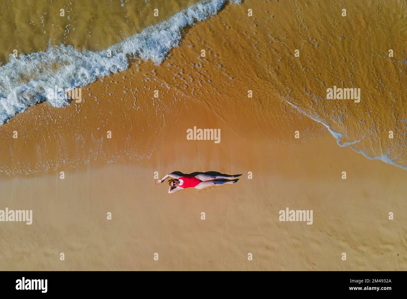 Woman In Red Swimsuit Lying On The Beautiful Sandy Beach With Ocean