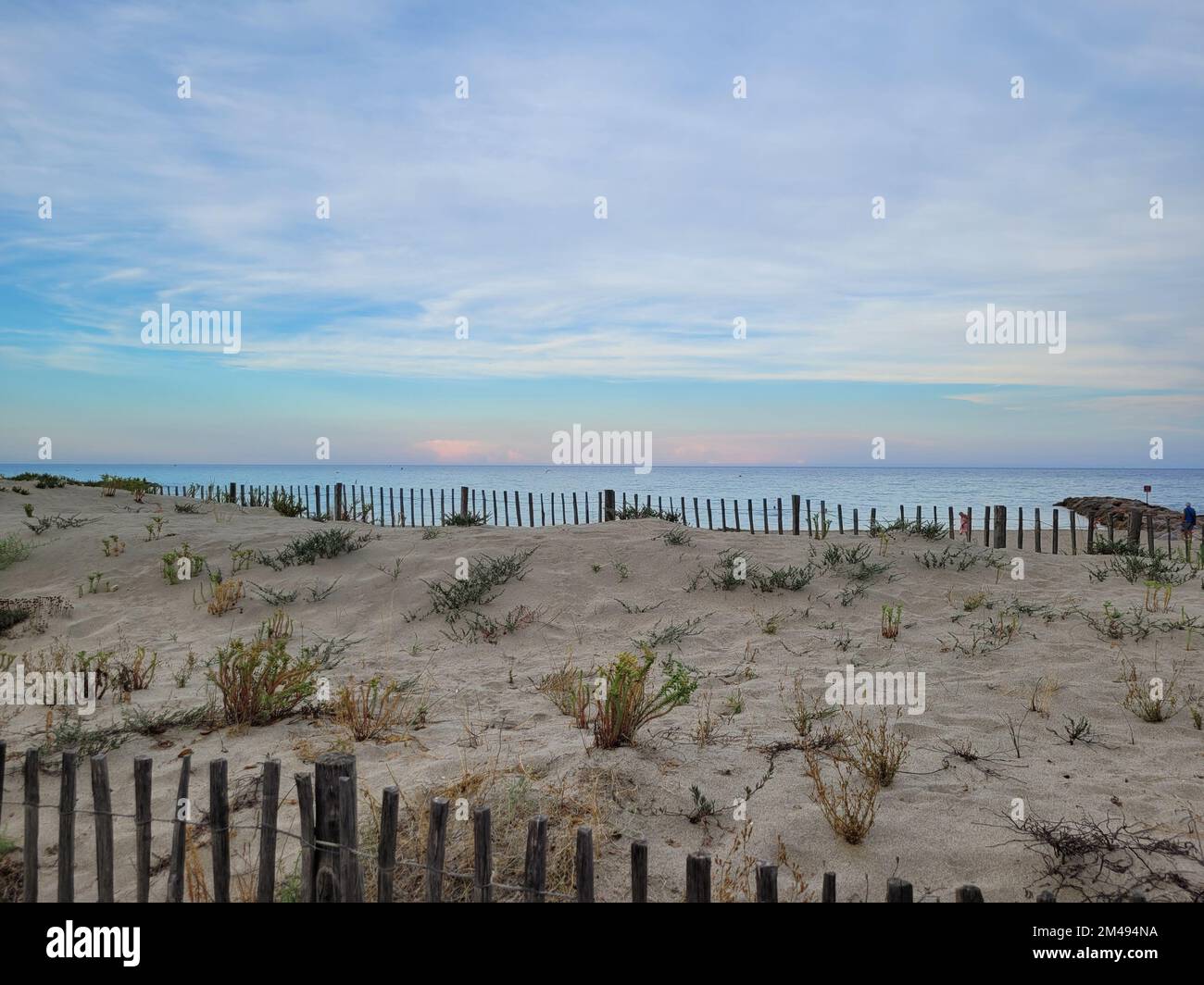 A white sandy beach with a wooden fence captured against the scenic ...