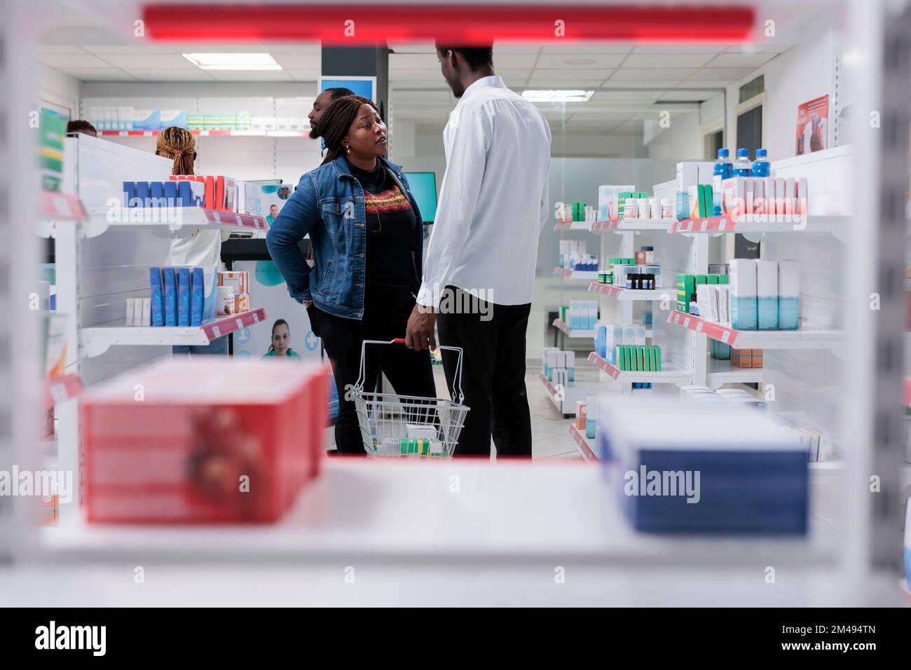 Customers buying medication in drugstore, standing in pharmacy aisle ...